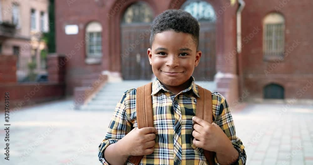 Close up portrait of happy cute African American male junior student ...