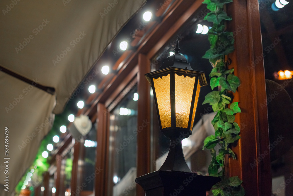 black iron retro street lighting lantern with glass shade in front of ...