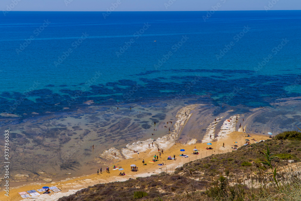 White limestone cliffs with beaches, swimmers, and different shades of ...