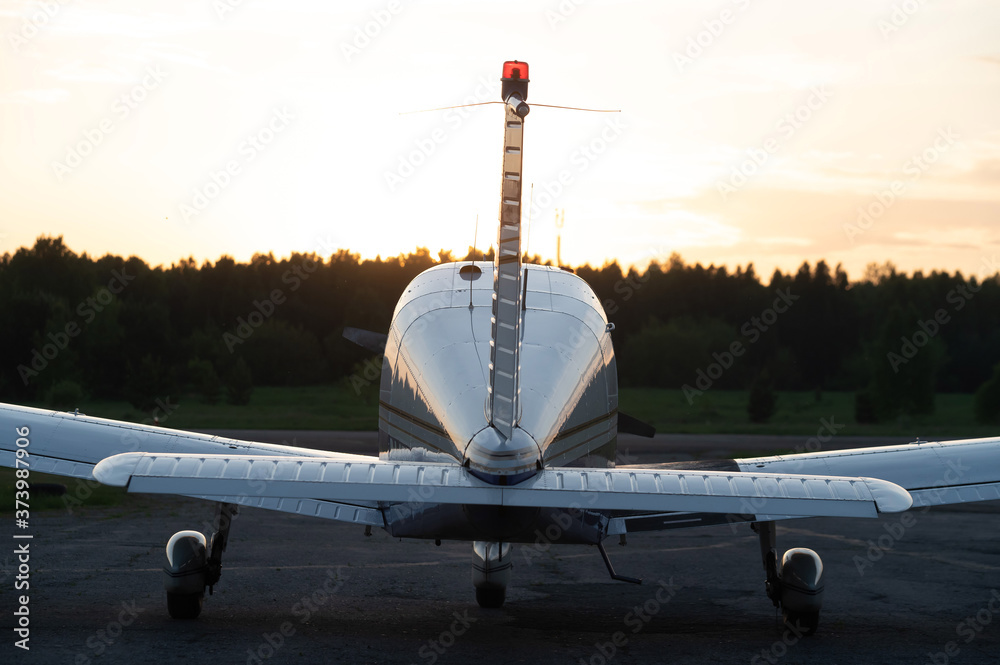 Quadruple aircraft parked at a private airfield. Rear view of a plane ...