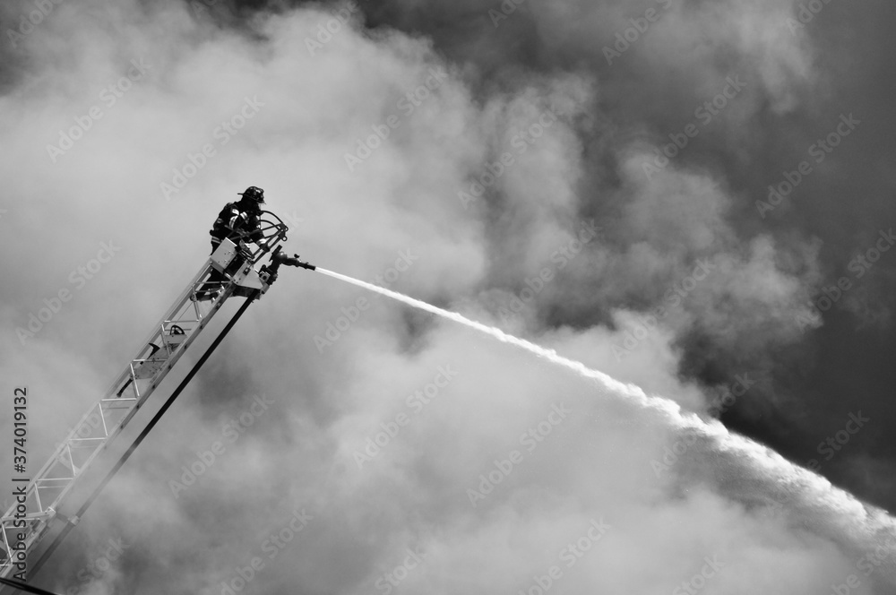 Fireman Spraying Water from Hydraulic Ladder Stock Photo | Adobe Stock