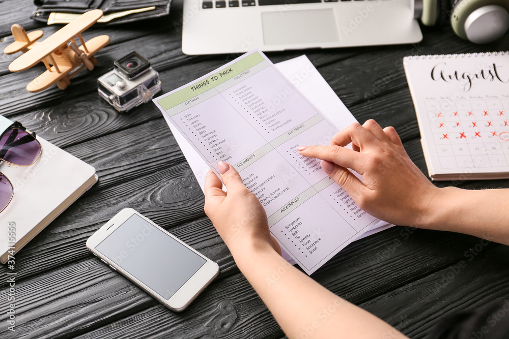 Woman making check-list of things to pack for travel Stock Photo ...