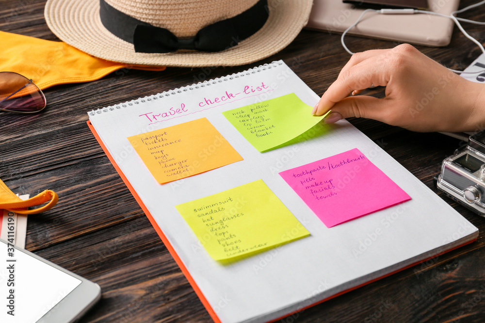 Woman making check-list of things to pack for travel Stock Photo ...