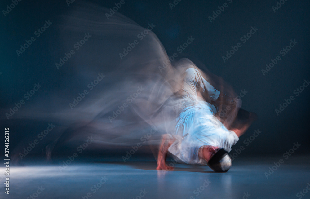 Stylish young guy breakdancer dancing hip-hop on the floor in neon ...