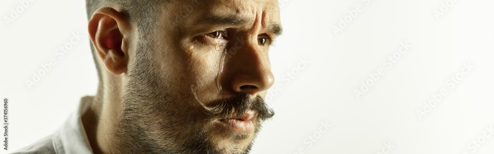 Crying. Caucasian young man's close up cropped shot on studio ...
