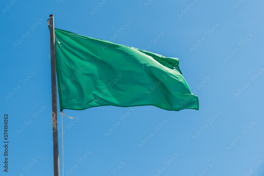 Waving green flag indicating the calmness of the sea Stock Photo ...
