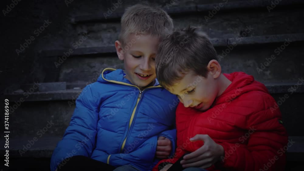 Two brothers play computer games. Friends play mobile games on ...