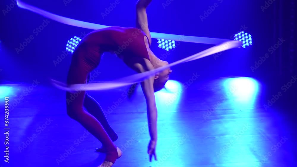 Rhythmic gymnastics. Flexible gymnast with tape creates beautiful hands ...