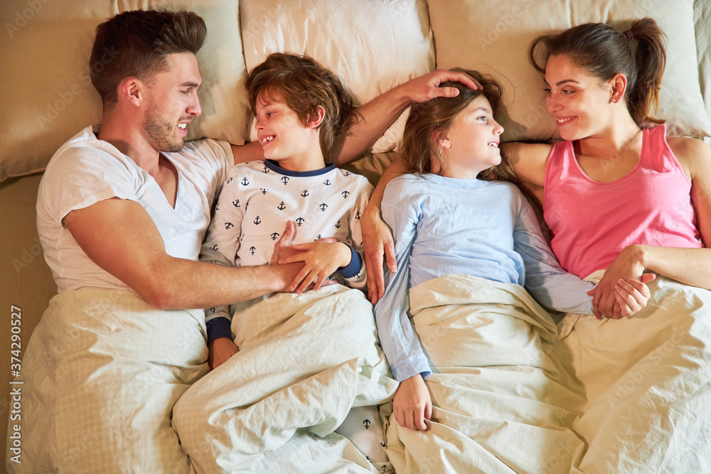 Eltern und Kinder kuscheln im Bett Stock Photo | Adobe Stock