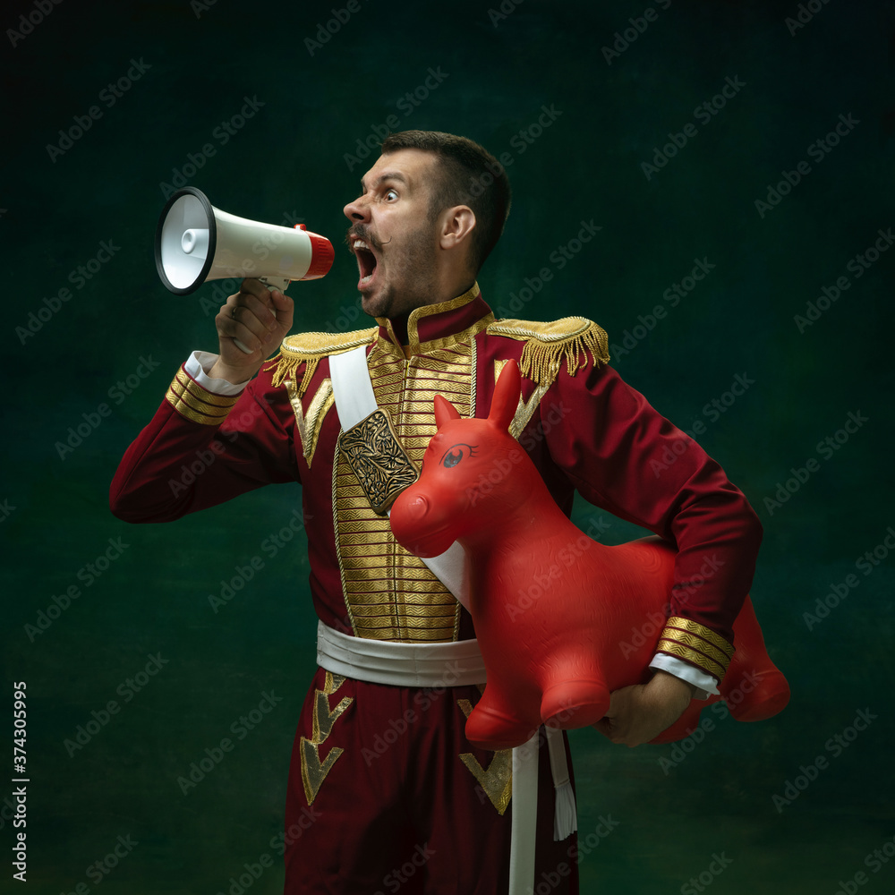 Shouting for sales. Young man in suit as Nicholas II isolated on dark ...