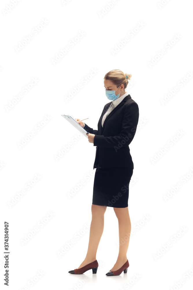 Working in face mask. Young woman, accountant, finance analyst or ...