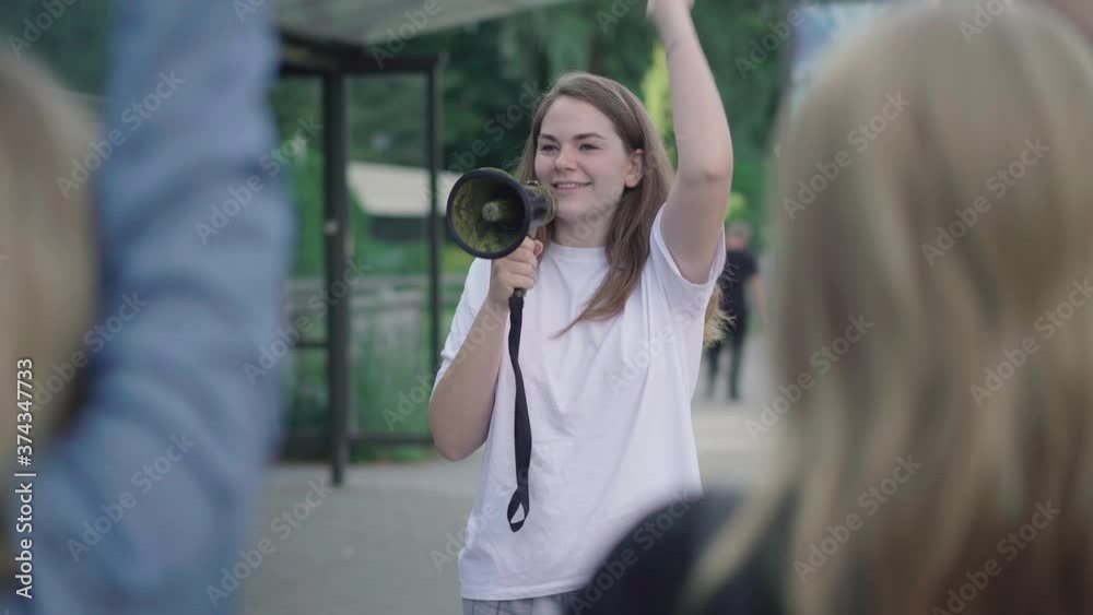 Portrait of protest leader with megaphone encouraging crowd with ...