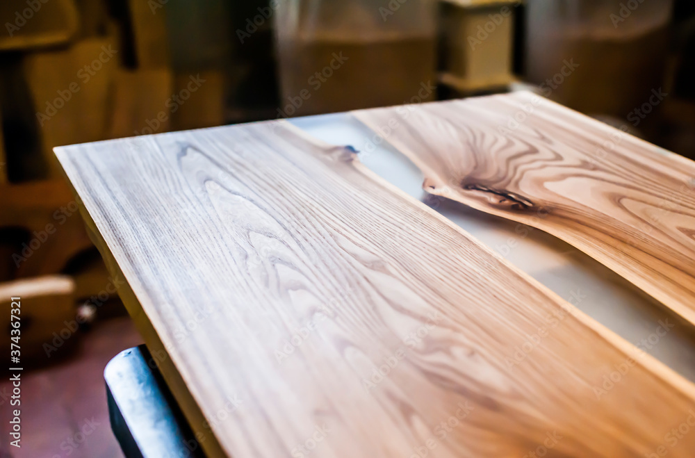 Epoxy-painted solid wood table top close-up in a carpentry workshop ...