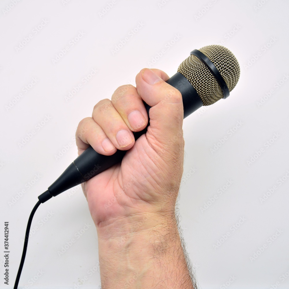 Mano empuñando un micrófono sobre fondo blanco Stock Photo | Adobe Stock