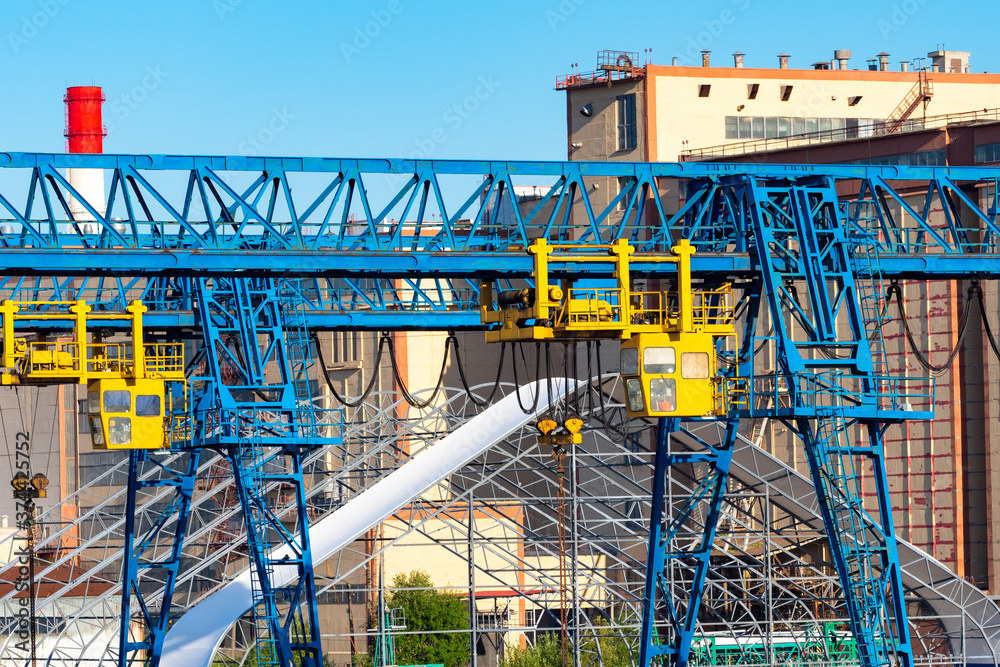 Overhead crane. Construction equipment on the background of buildings ...