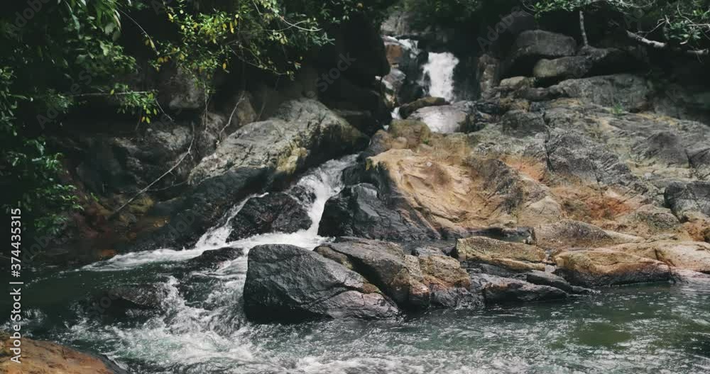 Thailand's tropic river: jungle waterfall fall to stony stream. Green ...