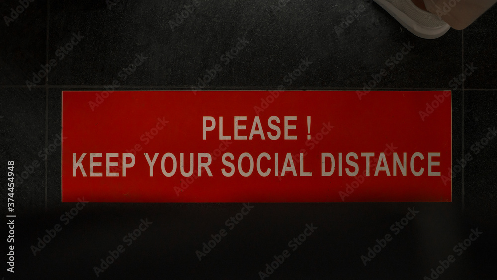 red attention sign with words please keep your social distance and ...