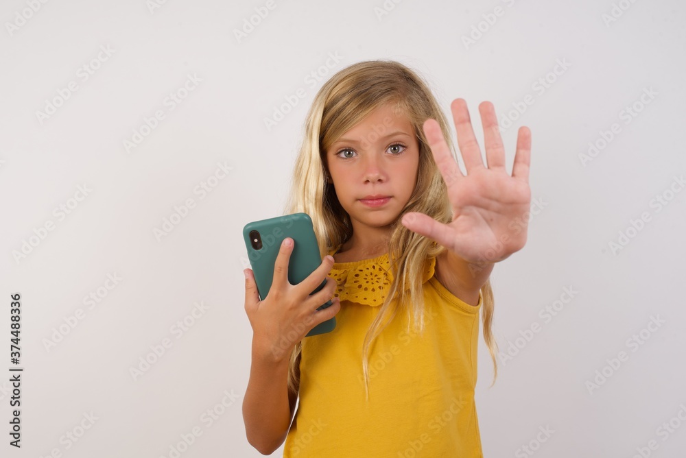 Little girl with beautiful blonde hair over white background using and ...