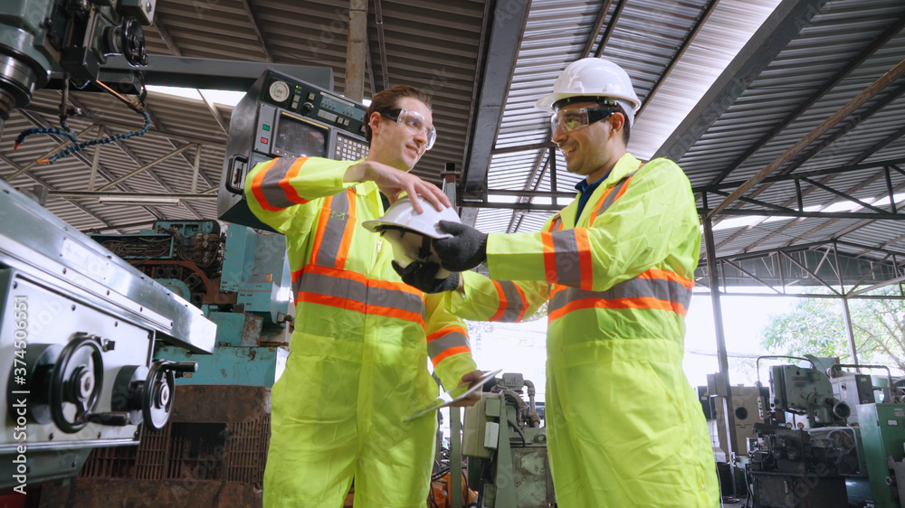 Factory worker warn coworker about safety and give hardhat to him ...