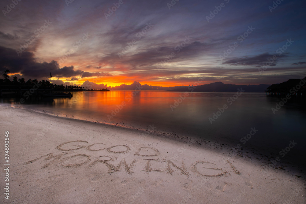 Good morning message written in the sand on a tropical island beach ...