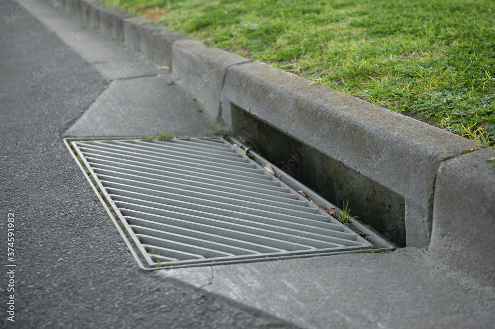 Gutter of a stormwater drainage system in perspective on the side of an ...
