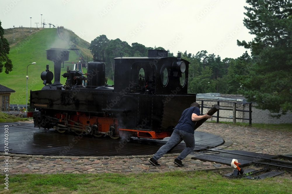 Steam engine on turning platform. Narrow-gauge railway in an amusement ...