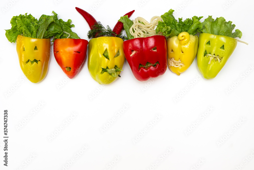 Multicolored stuffed peppers with various cutout faces in the skin on a ...