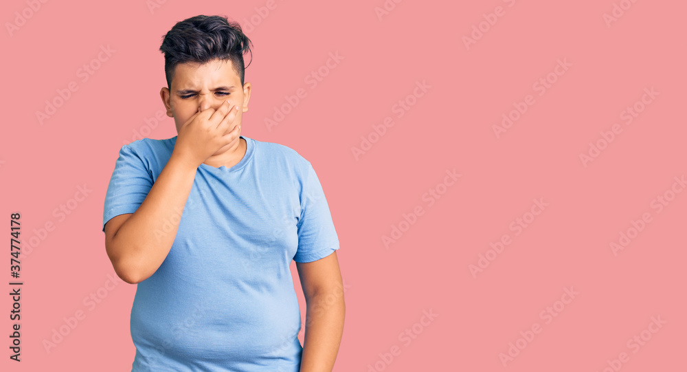 Little boy kid wearing sports workout clothes smelling something stinky ...