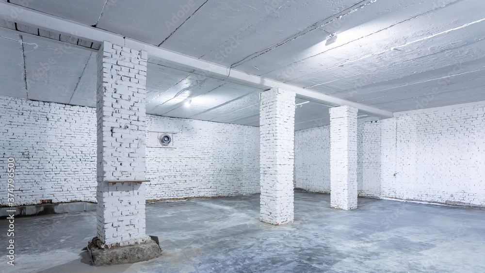 Industrial building interior with white brick walls, concrete floor and ...
