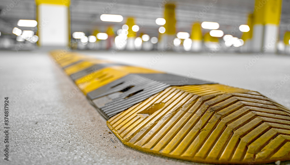 Traffic safety speed bump on an asphalt road in a parking area. Speed ...