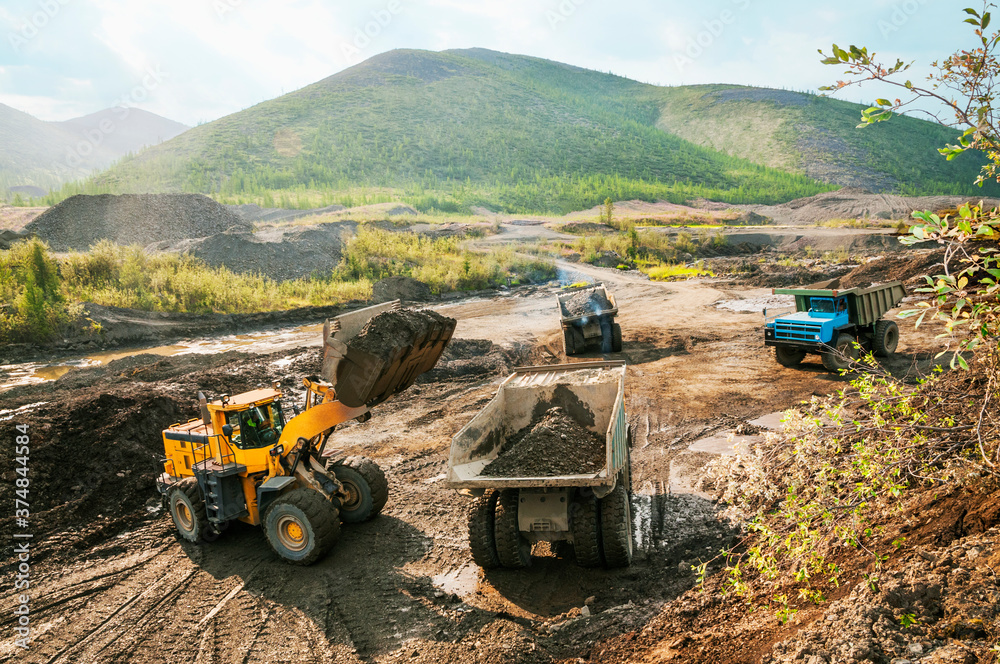 Front loader loads mountain soil into a dump truck bucket. Stock Photo ...