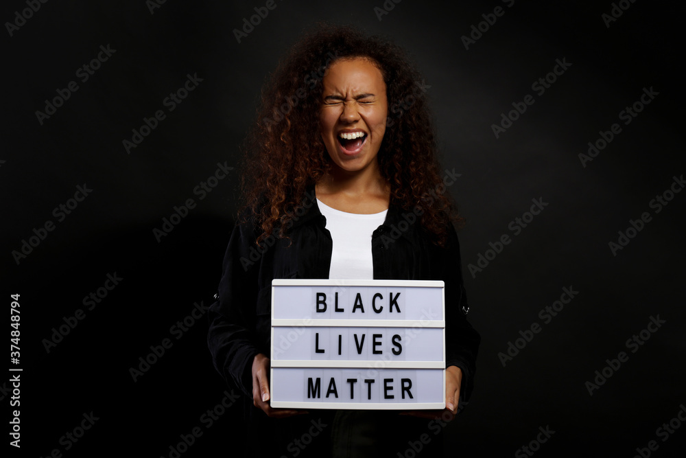 Portrait of young beautiful black woman standing in the dark with anti ...