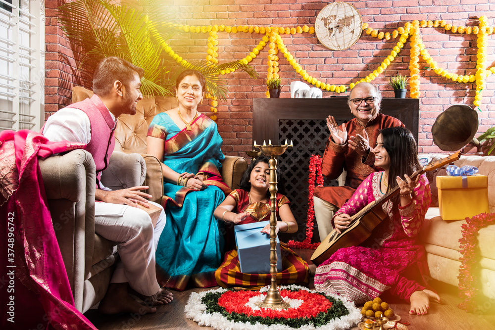 Happy Indian family singing, playing music, guitar while celebrating ...