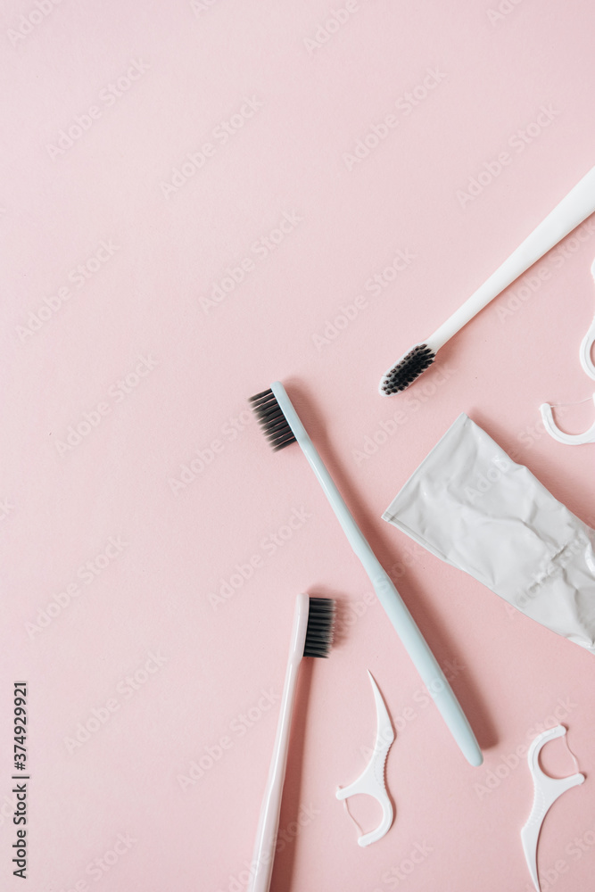 Oral care products: toothbrushes, toothpaste, flossers on pink ...