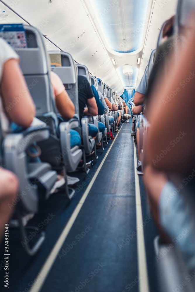 A narrow aisle between the rows of passenger seats in the cabin of a ...