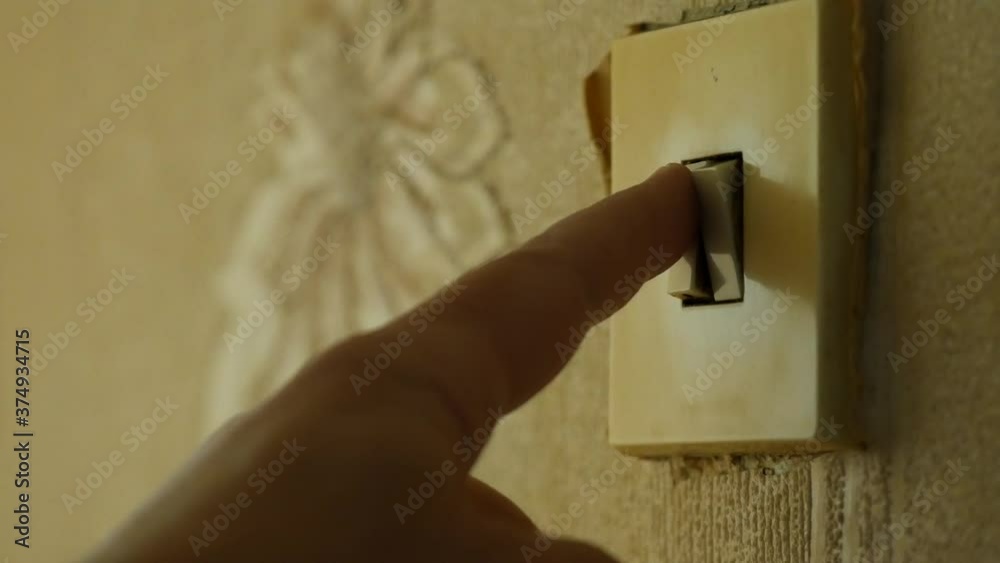 Man hand touches the buttons of light switch. Lamp wall switch. Man ...