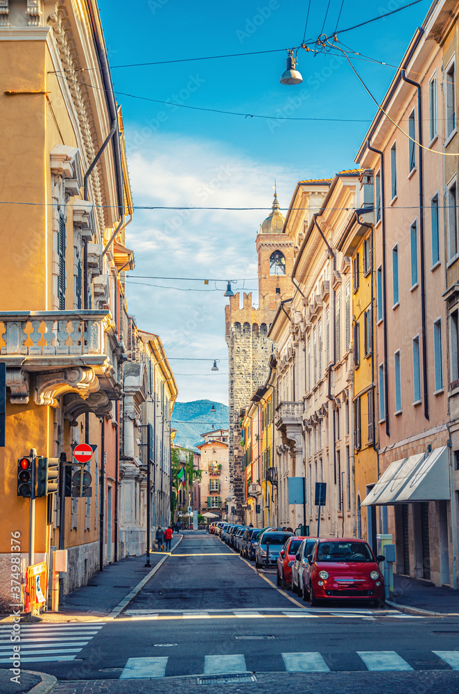 Typical italian street with parked cars and Torre della Pallata brick ...