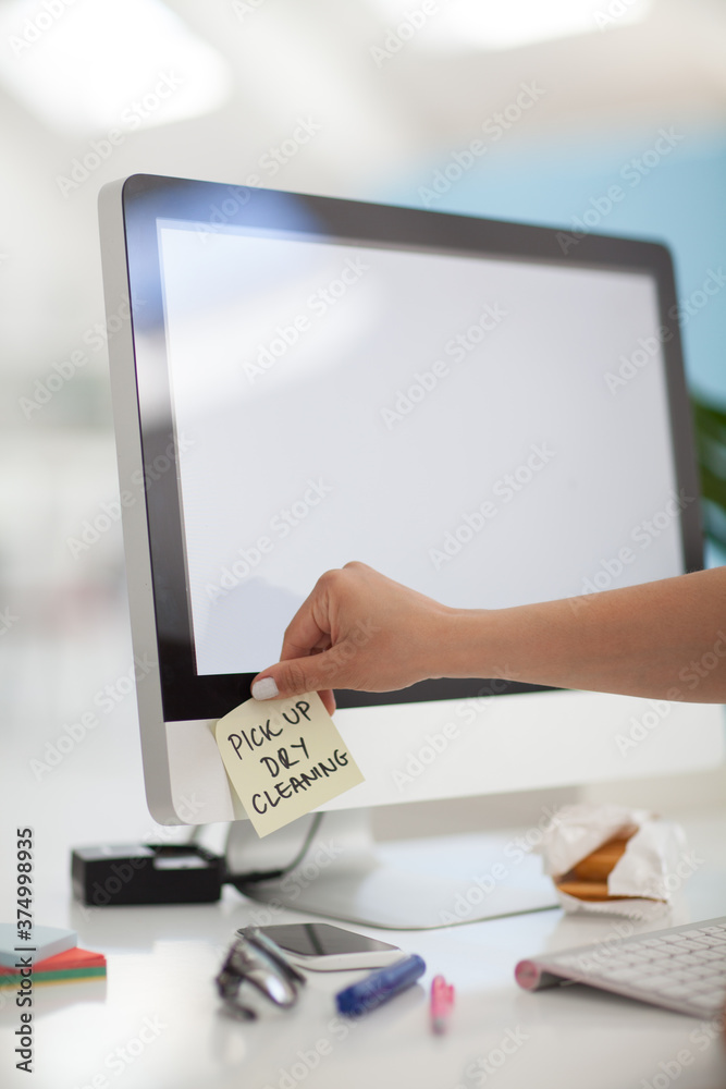 Woman sticking post it reminders on her desktop monitor. Stock Photo ...