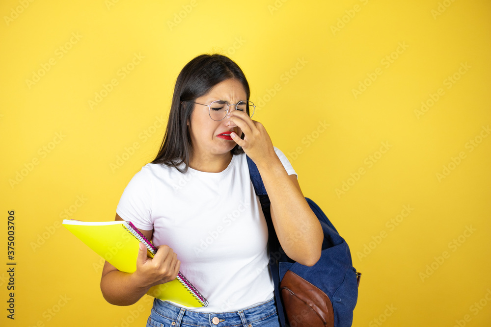 Young beautiful student woman wearing backpack holding notebook over ...