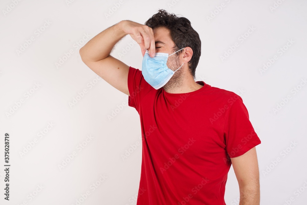 Young caucasian man with short hair wearing medical mask standing over ...