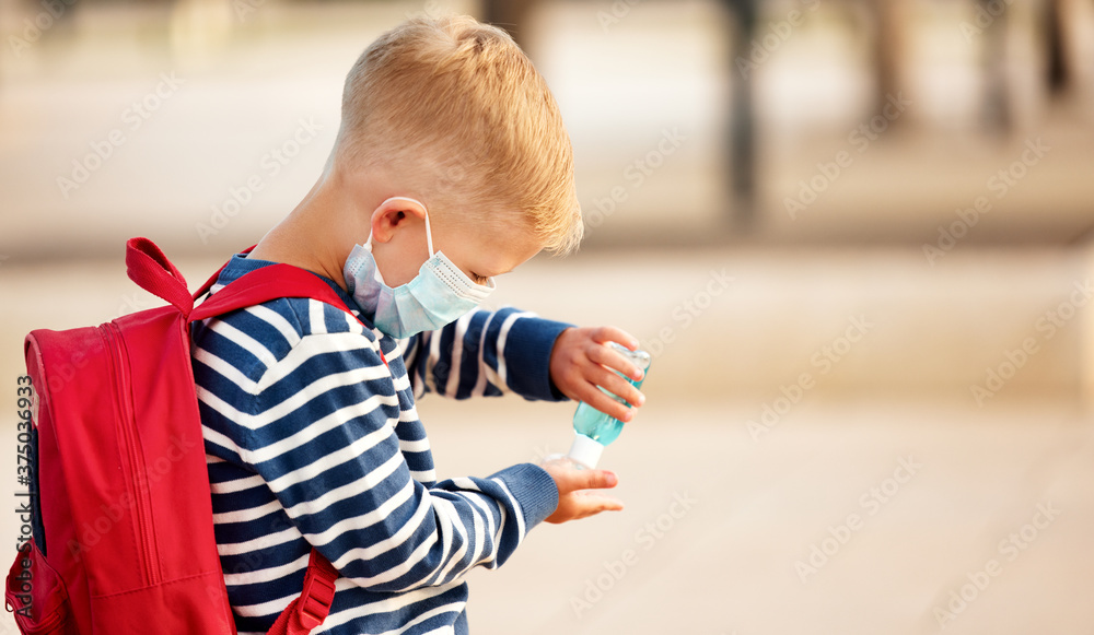 Little schoolkid disinfecting hands with sanitizer. Stock Photo | Adobe ...