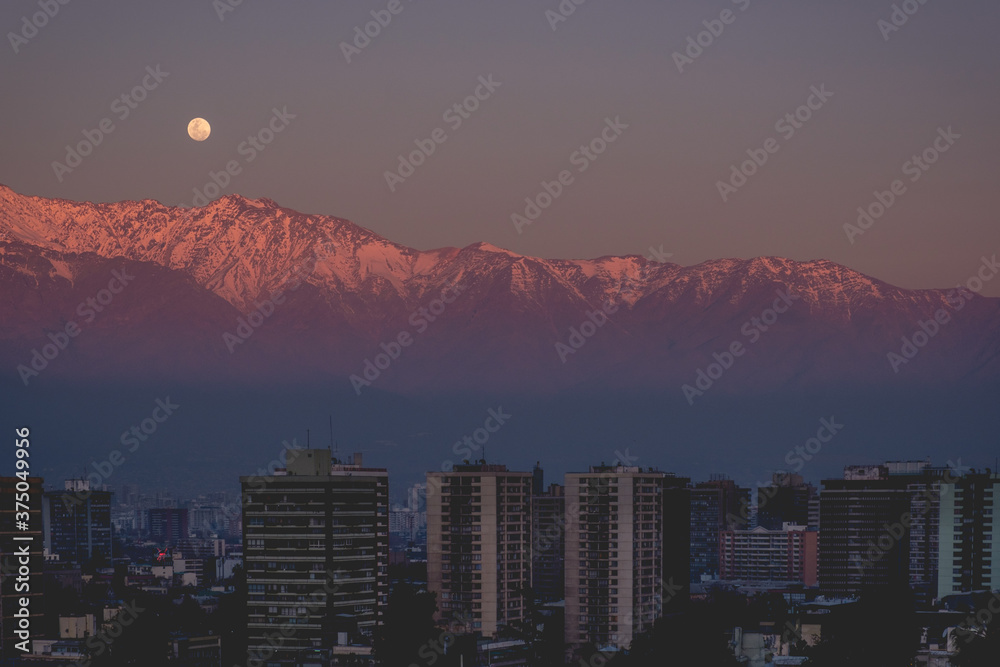 Beautiful sunset sky over Santiago downtown with full Moon and snowed ...