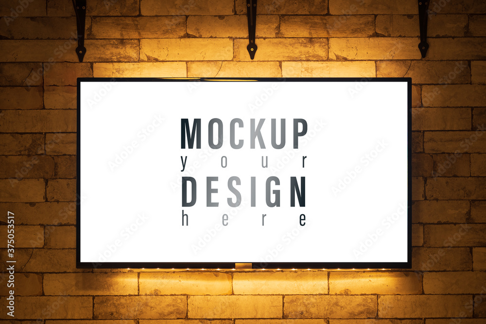 Mockup glowing TV screen at night with white screen on brick wall of ...