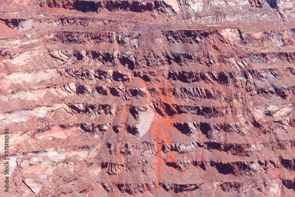 Close-up of red mining levels at iron ore quarry. Open-cast mine, open ...