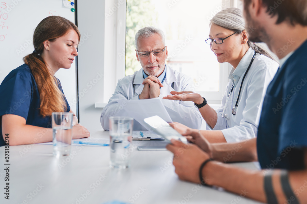 Team of healthcare workers discussing in boardroom with asian female ...