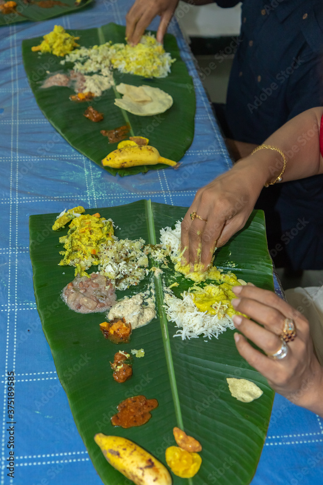 Traditional Kerala food being eaten on a banana leaf during the Onam ...