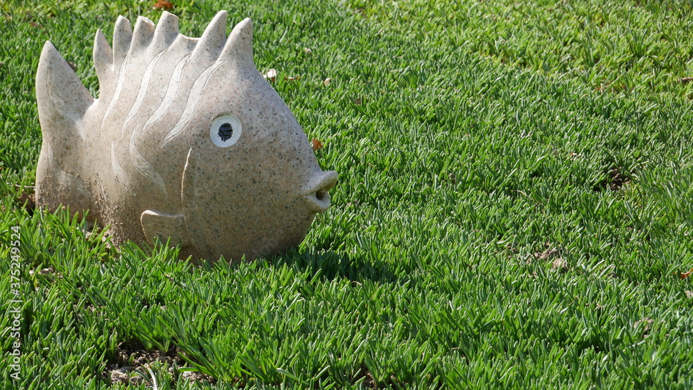 stone fish statue in green field Stock Photo | Adobe Stock