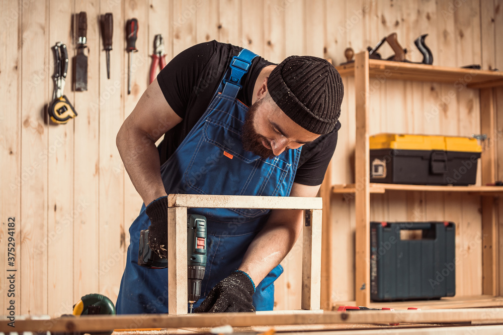 Carpenter working with an electric screwdriver screwing wood , Install ...