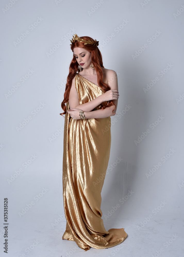 Full length portrait of girl with red hair wearing long grecian toga ...