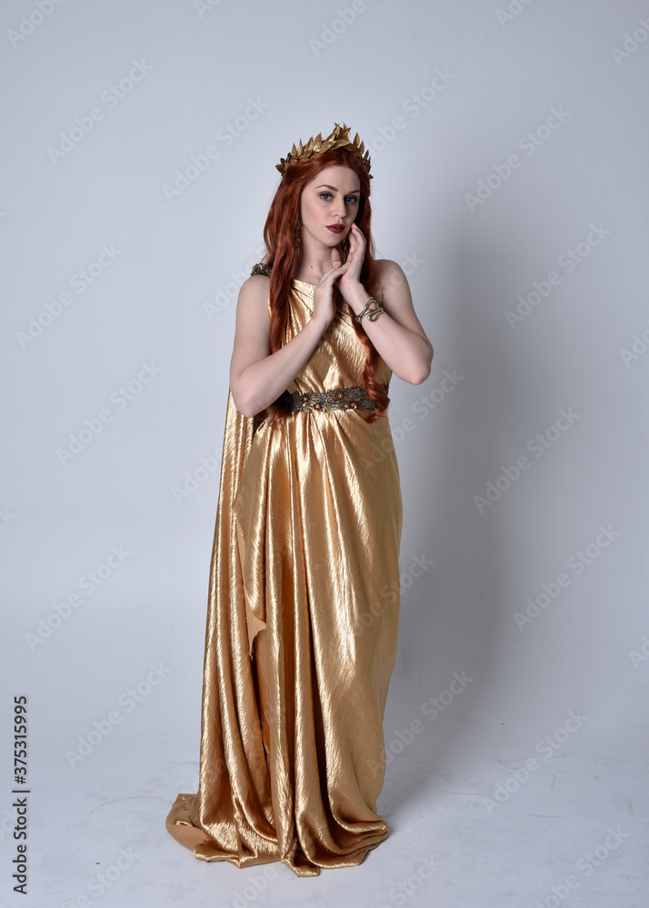 Full length portrait of girl with red hair wearing long grecian toga ...